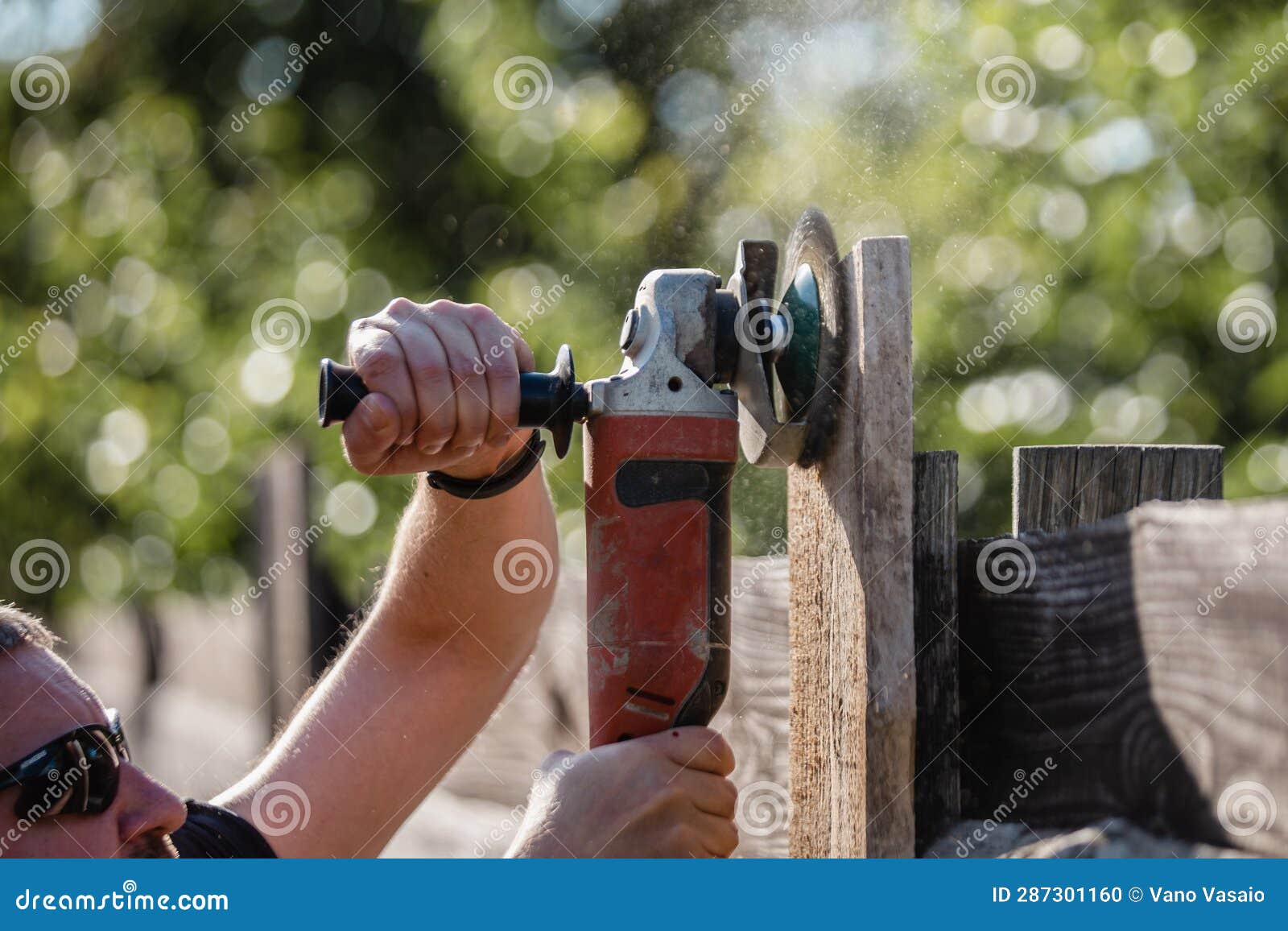 A Man with a Powerful Tool with an Angle Grinder Cleans the Wood of the ...