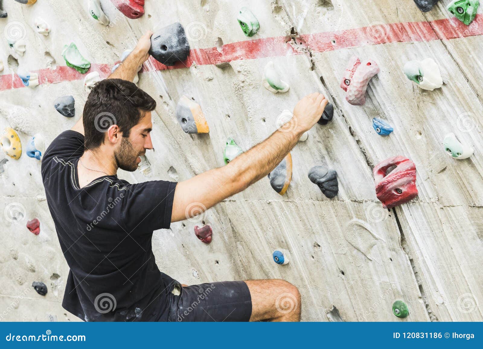 Man Practicing Rock Climbing on Artificial Wall Indoors. Active Stock ...