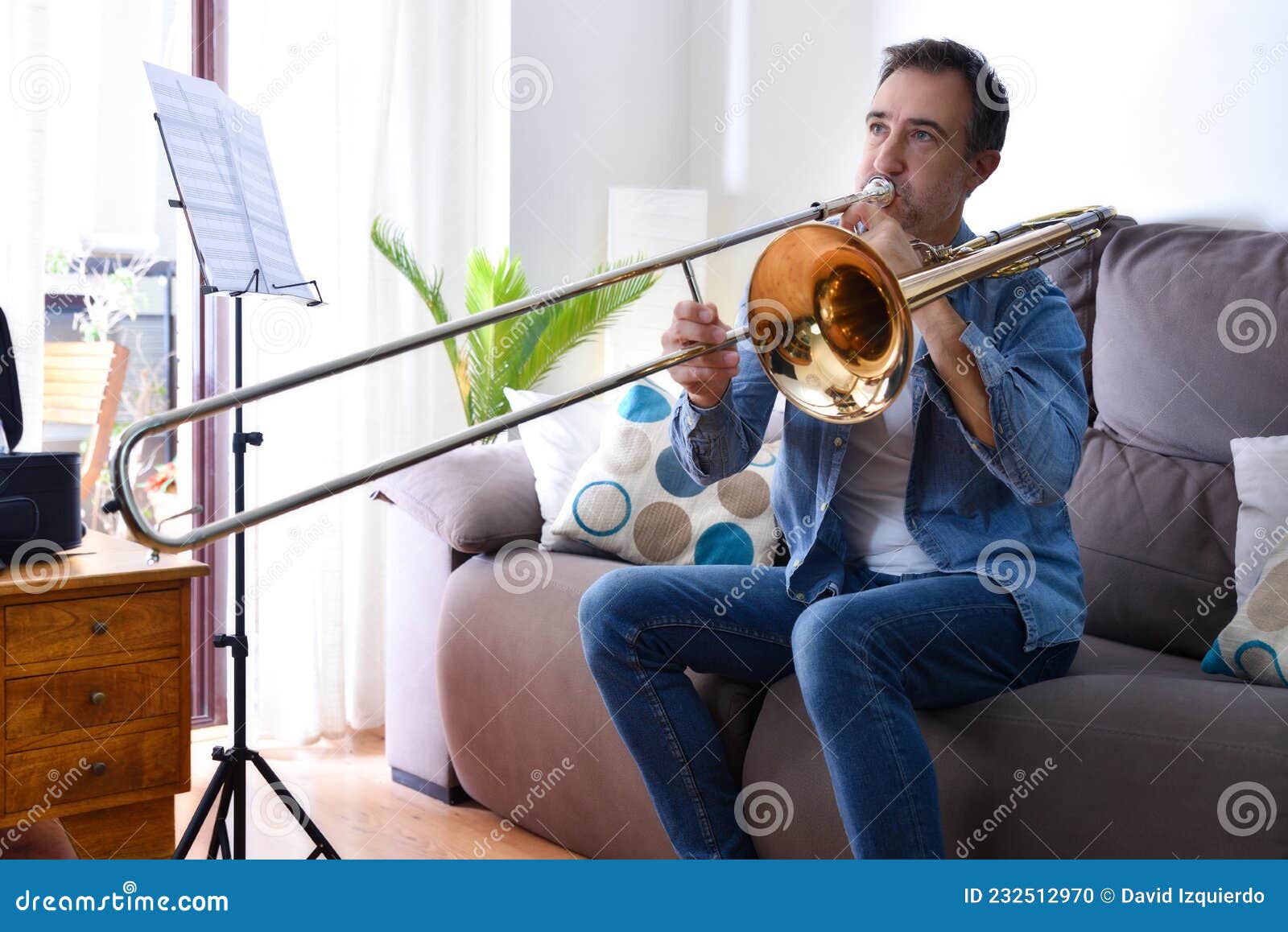Man Practicing Trombone with Enthusiasm in Living Room at Home Stock ...