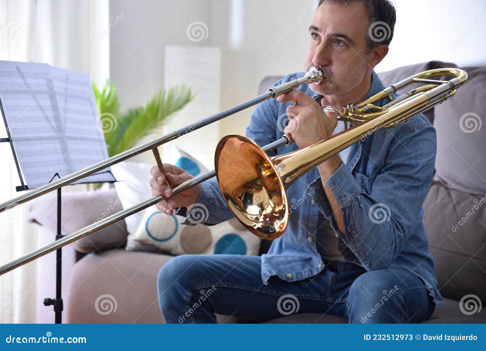 Man Practicing Trombone in a Sofa at Home Stock Image - Image of male ...