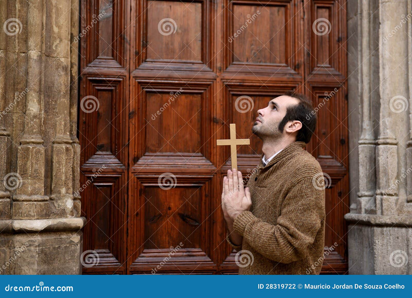 Man Praying in Front of the Church Holding a Cross Stock Photo - Image ...