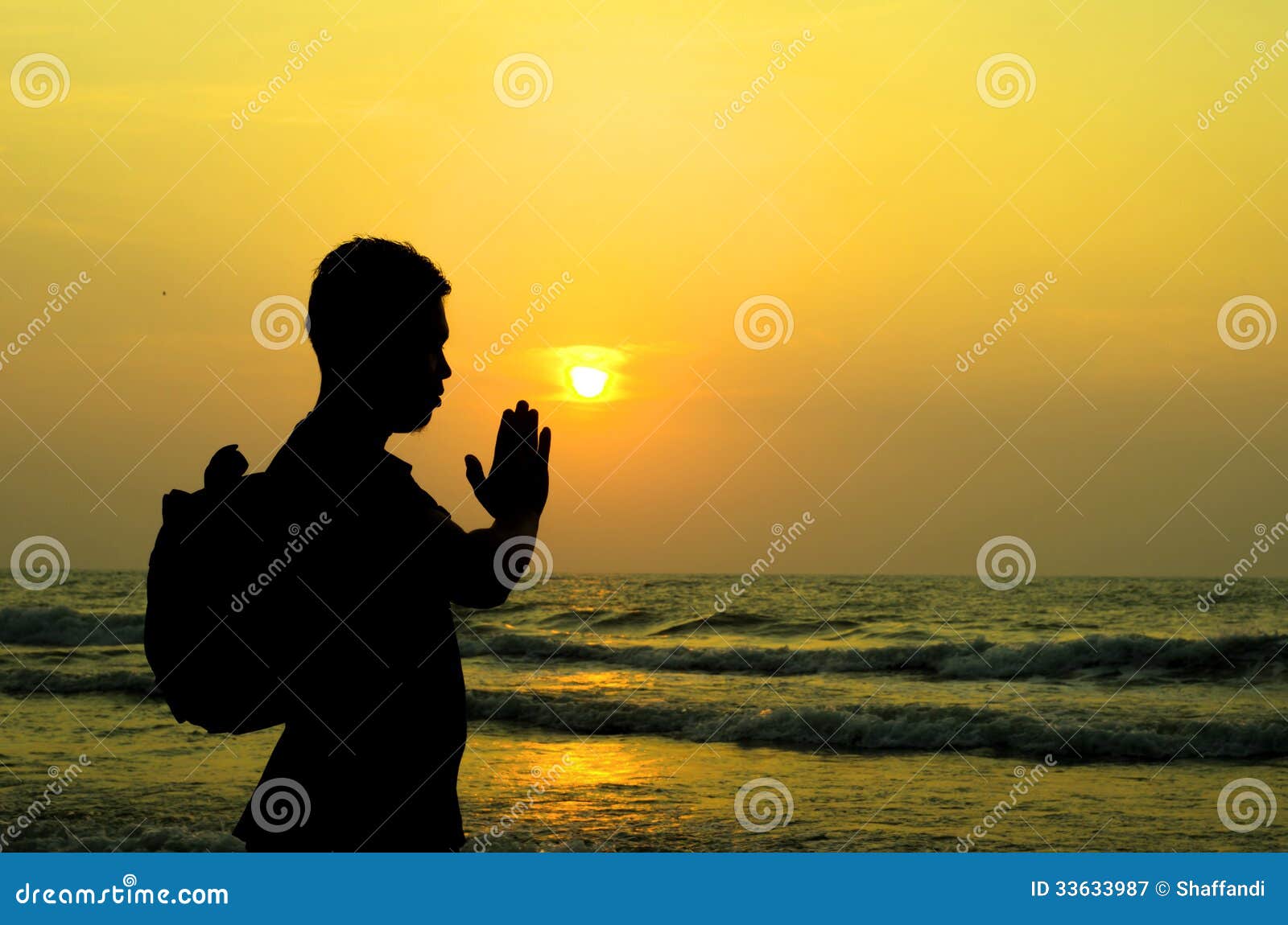 A Man Praying in Front of a Golden Sunrise on the Beach Stock Image ...