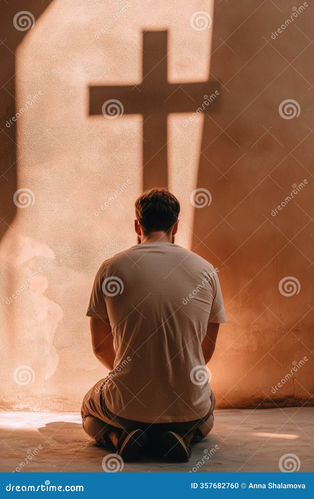 Man Praying in Sunlit Room with Cross Shadow on Wall Stock Photo ...