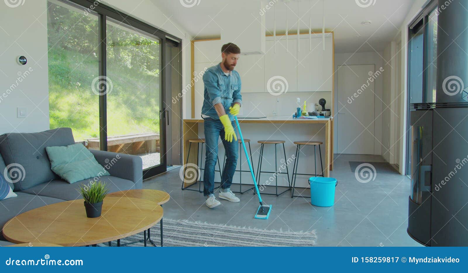 Man In Protective Gloves Is Singing Using A Mop And Dancing While