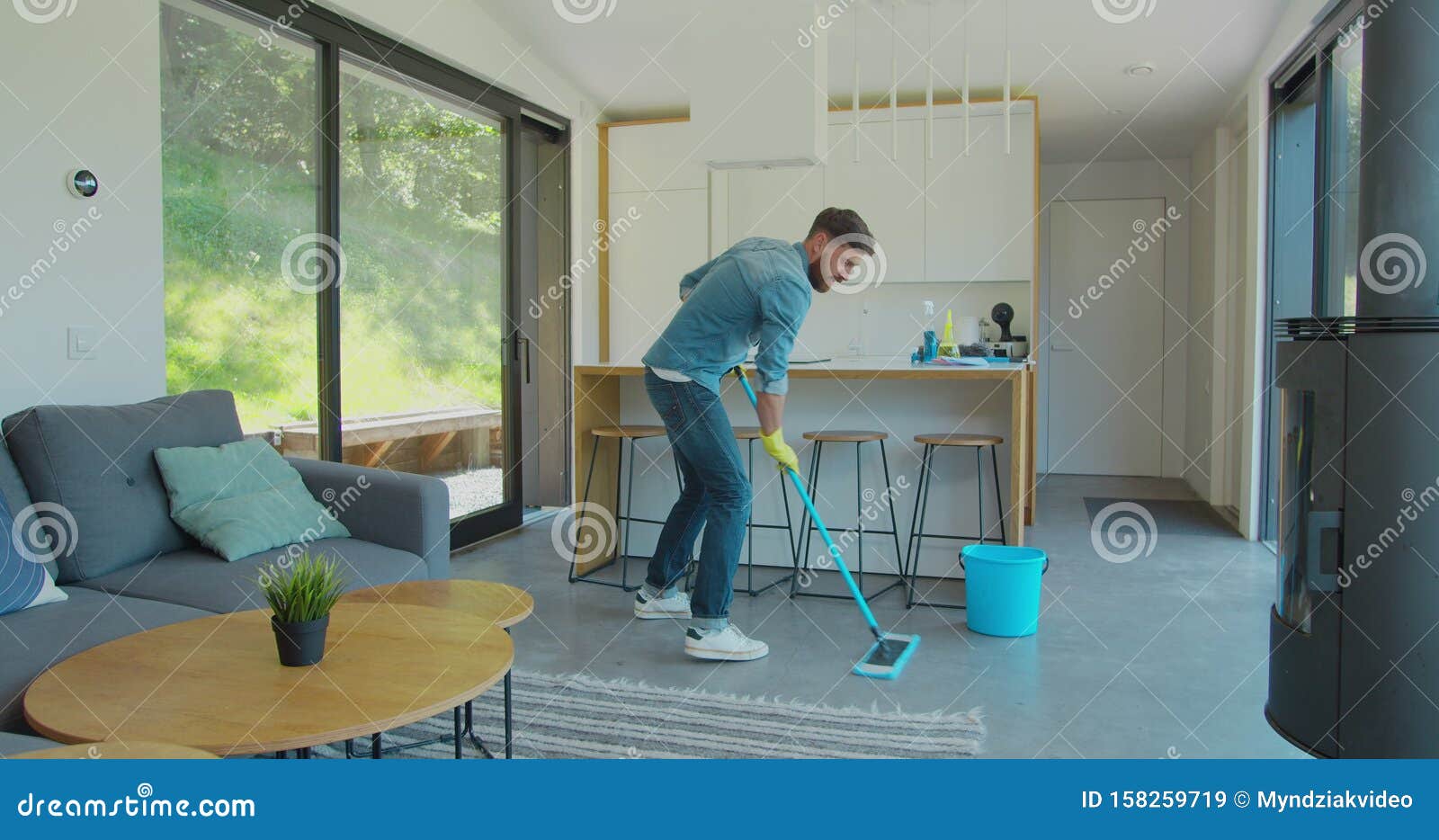 Man In Protective Gloves Is Singing Using A Mop And Dancing While