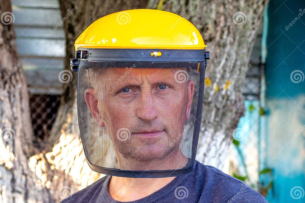 A Man with a Protective Mask for Safety while Mowing the Grass Stock ...
