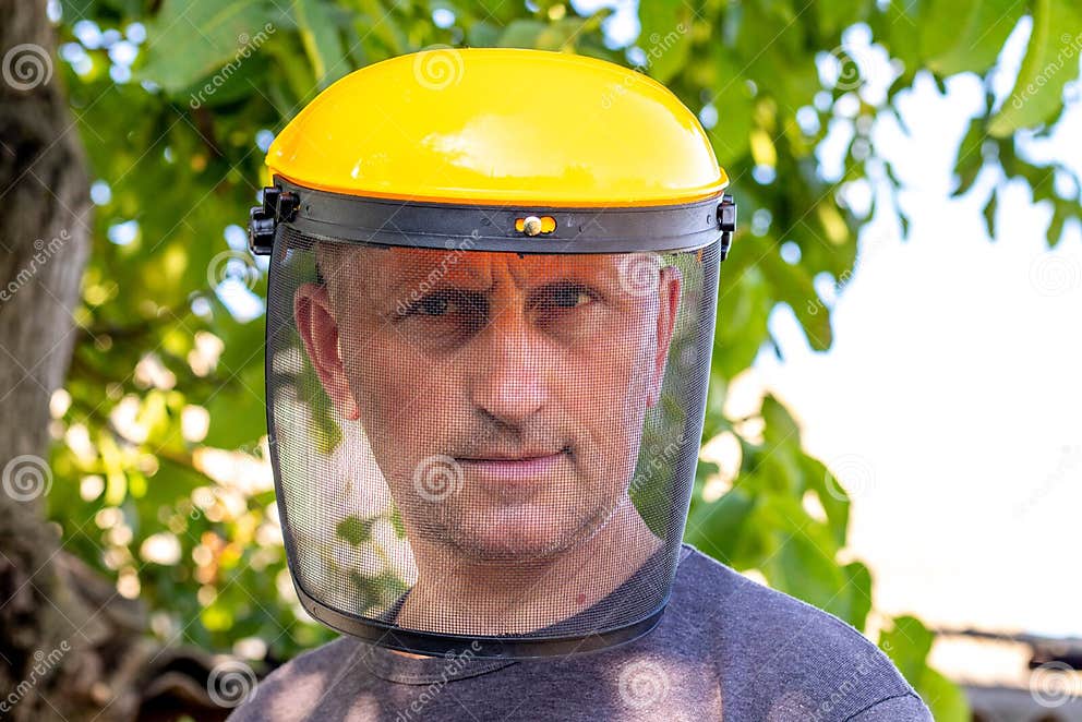 A Man with a Protective Mask for Safety while Mowing the Grass Stock ...