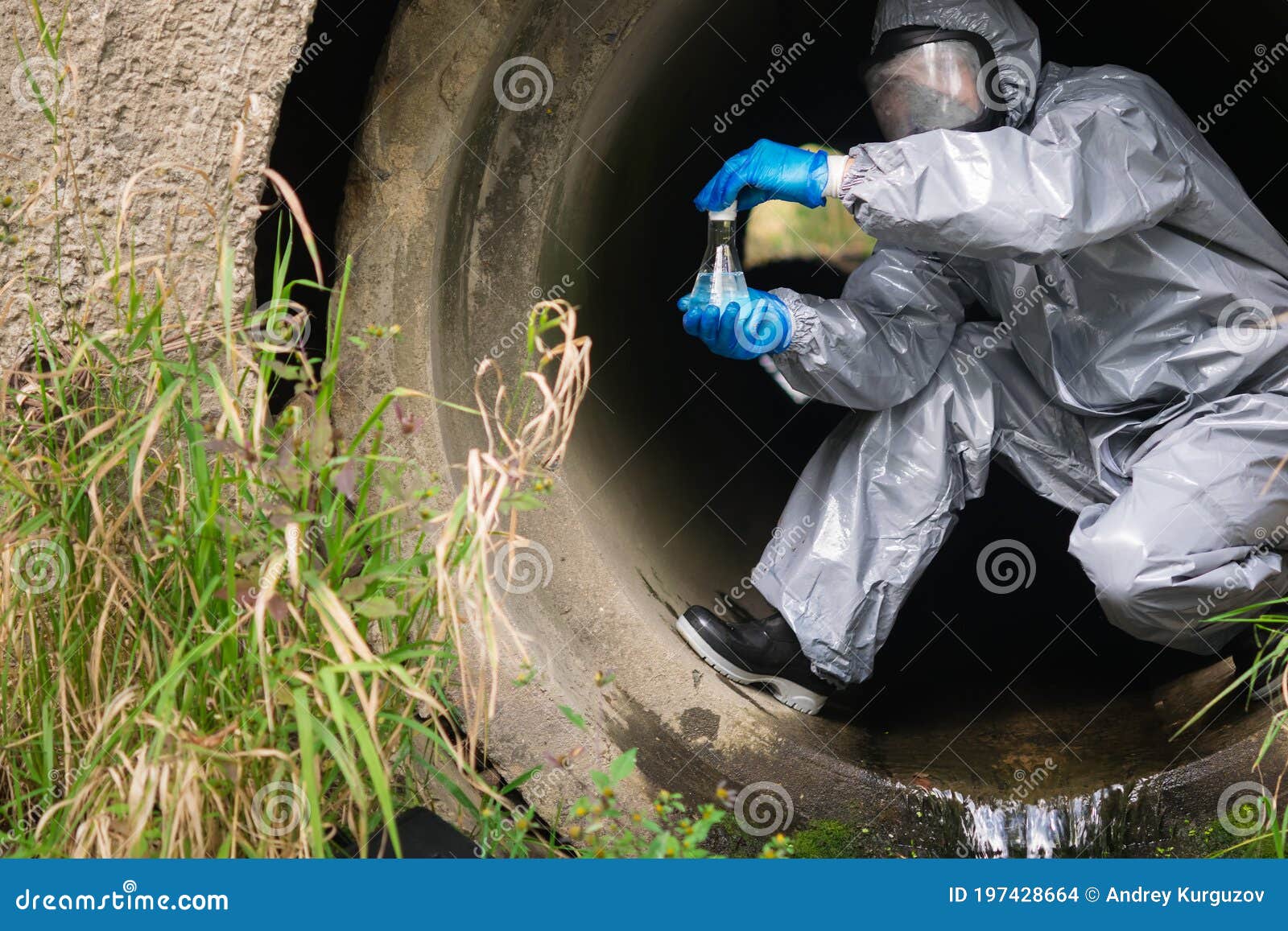 A Man in a Protective Suit and Mask in a Large Sewer Took a Sample of ...