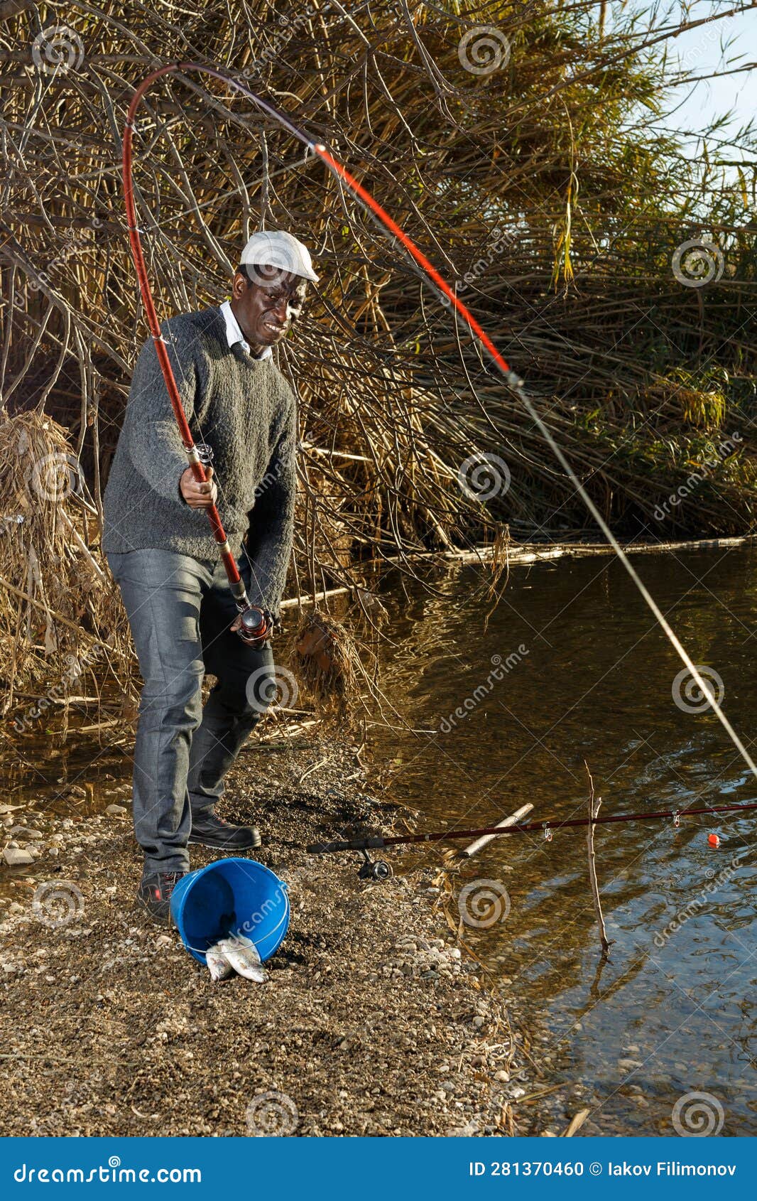 Man and Pulling Fish Near River Stock Photo - Image of male, alone ...