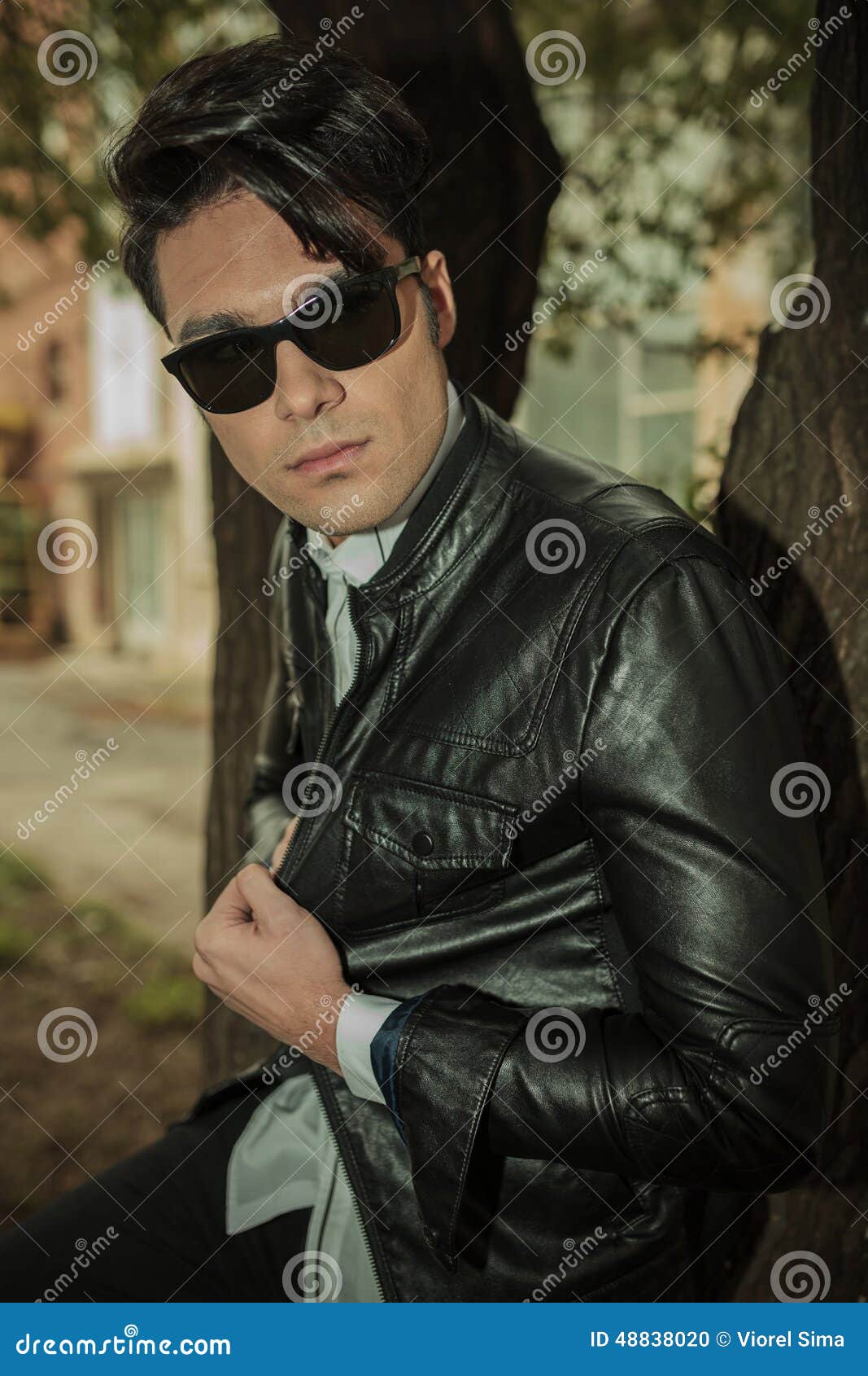 Man Pulling His Jacket while Leaning on a Tree Stock Photo - Image of ...