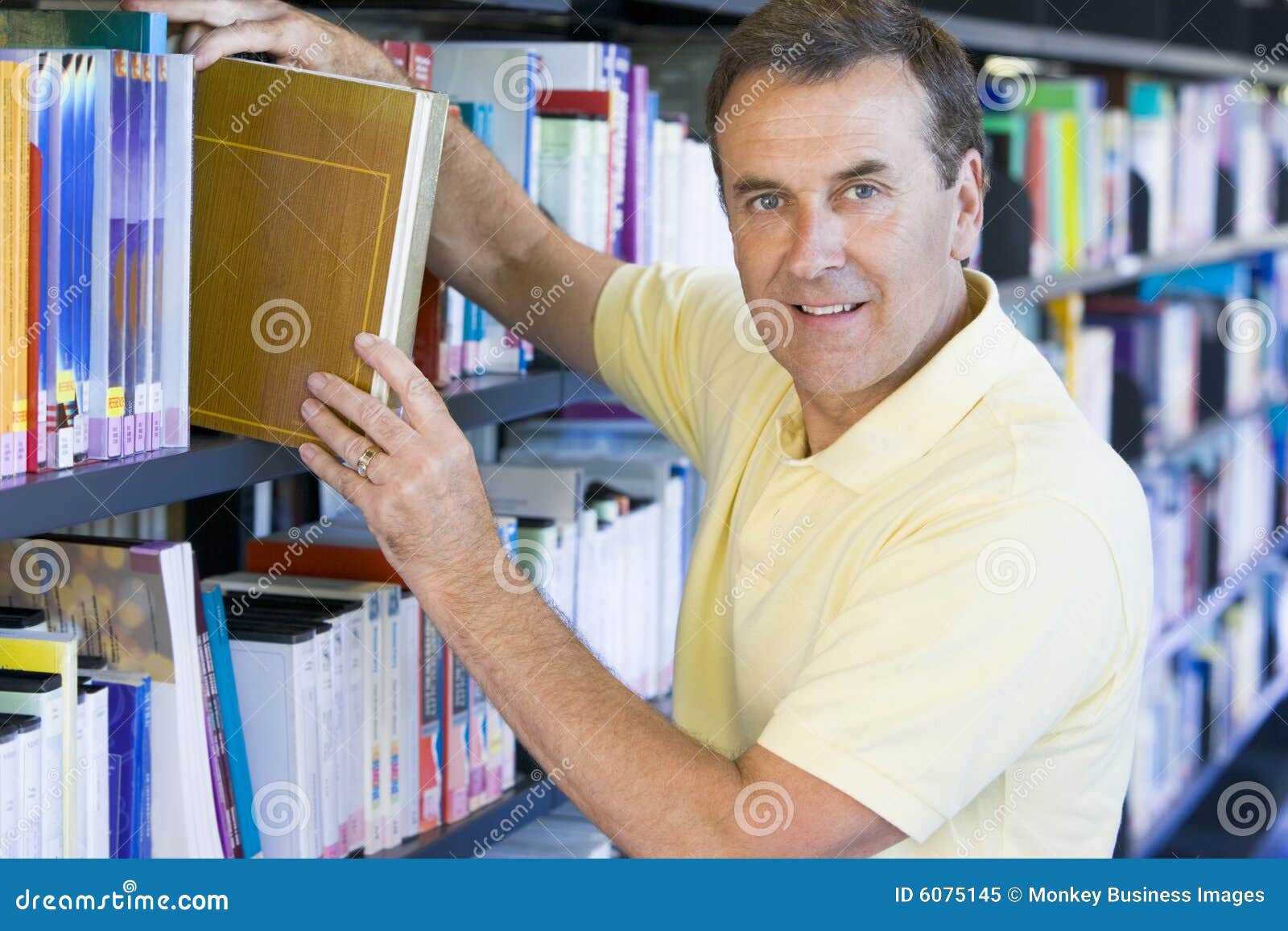 Man Pulling a Library Book Off Shelf Stock Image - Image of pulling ...