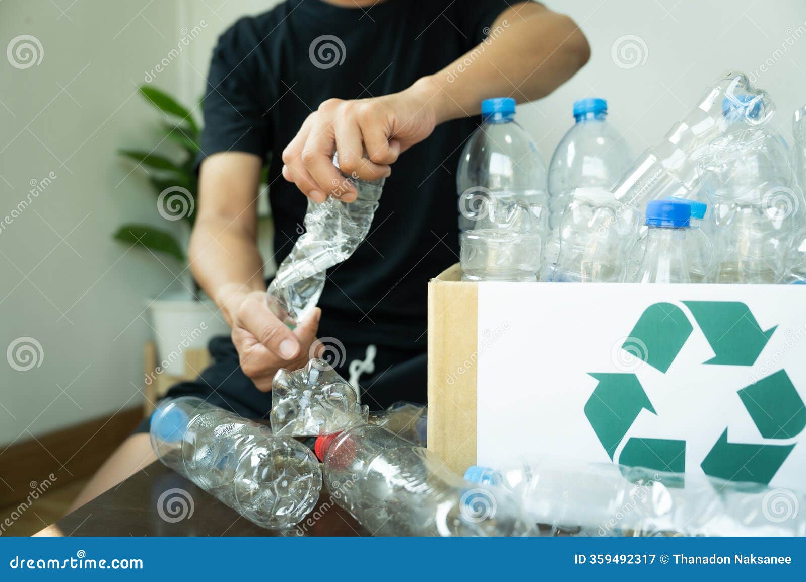 A Man is Pulling a Plastic Bottle Out of a Box. the Box is Labeled with ...