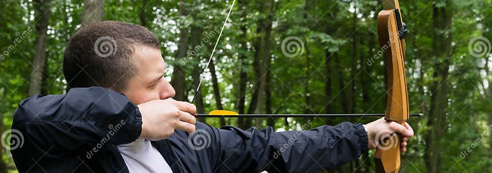 Man Pulls a Bow String for a Shot in the Forest, Close-up, Long Photo ...