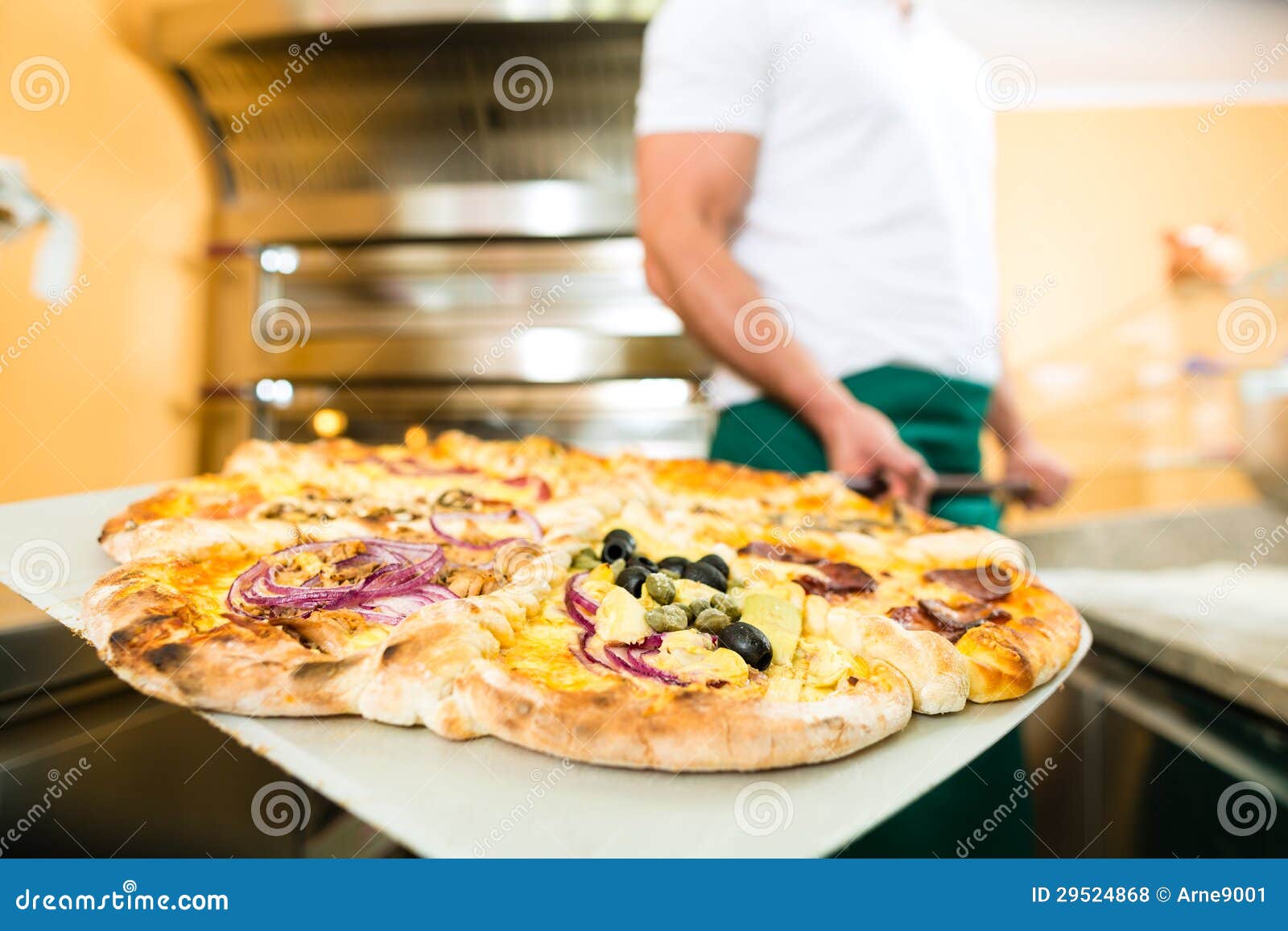 Man Pushing the Finished Pizza from the Oven Stock Photo - Image of ...