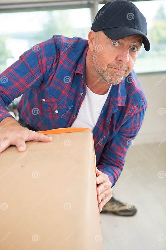 Man pushing heavy package stock image. Image of service - 271543713