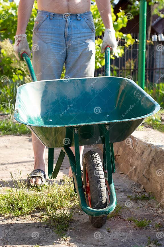 Man pushing wheelbarrow stock image. Image of person - 14567251