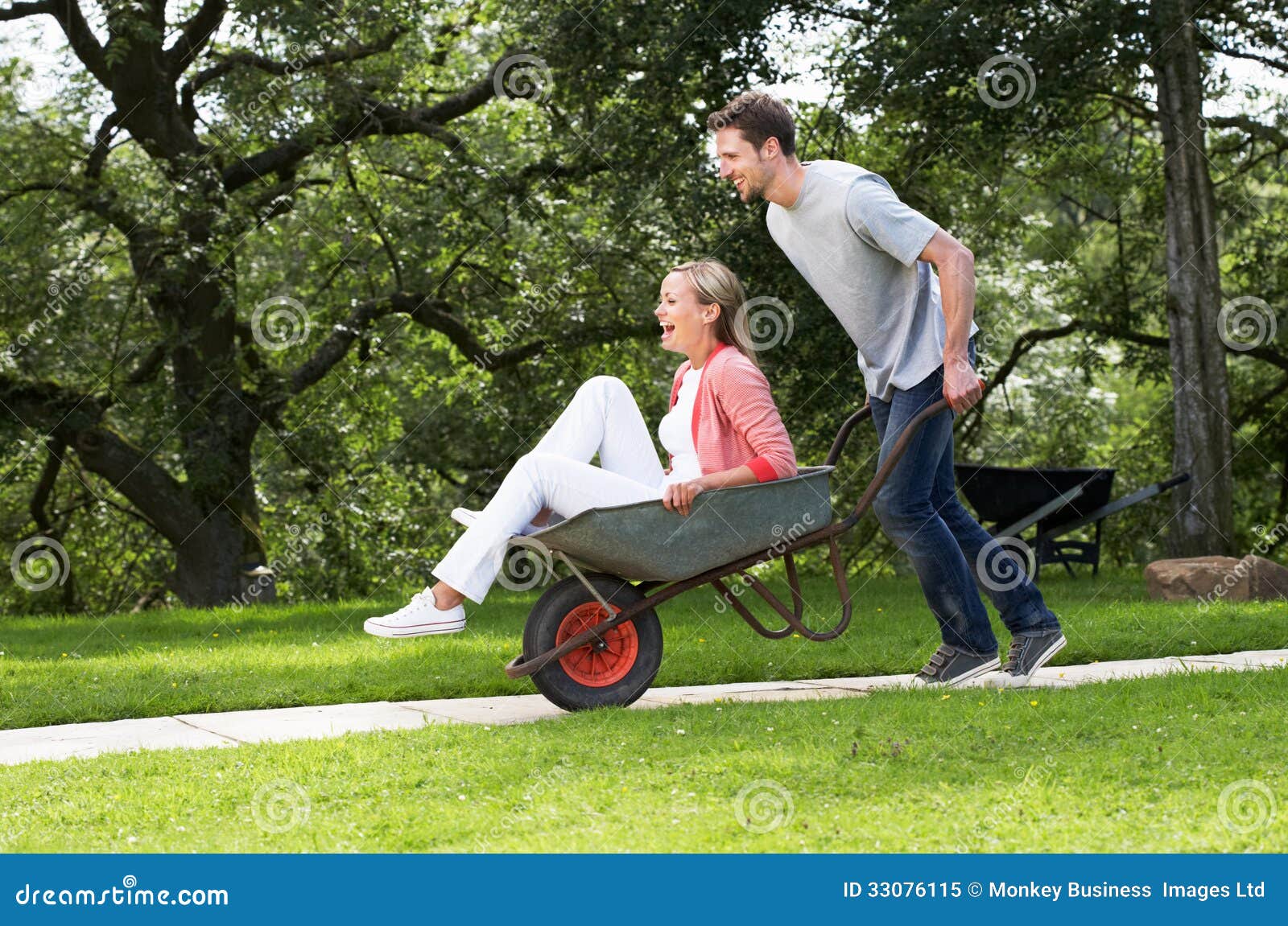 Man Pushing Woman in Wheelbarrow Stock Image - Image of male, barrow ...
