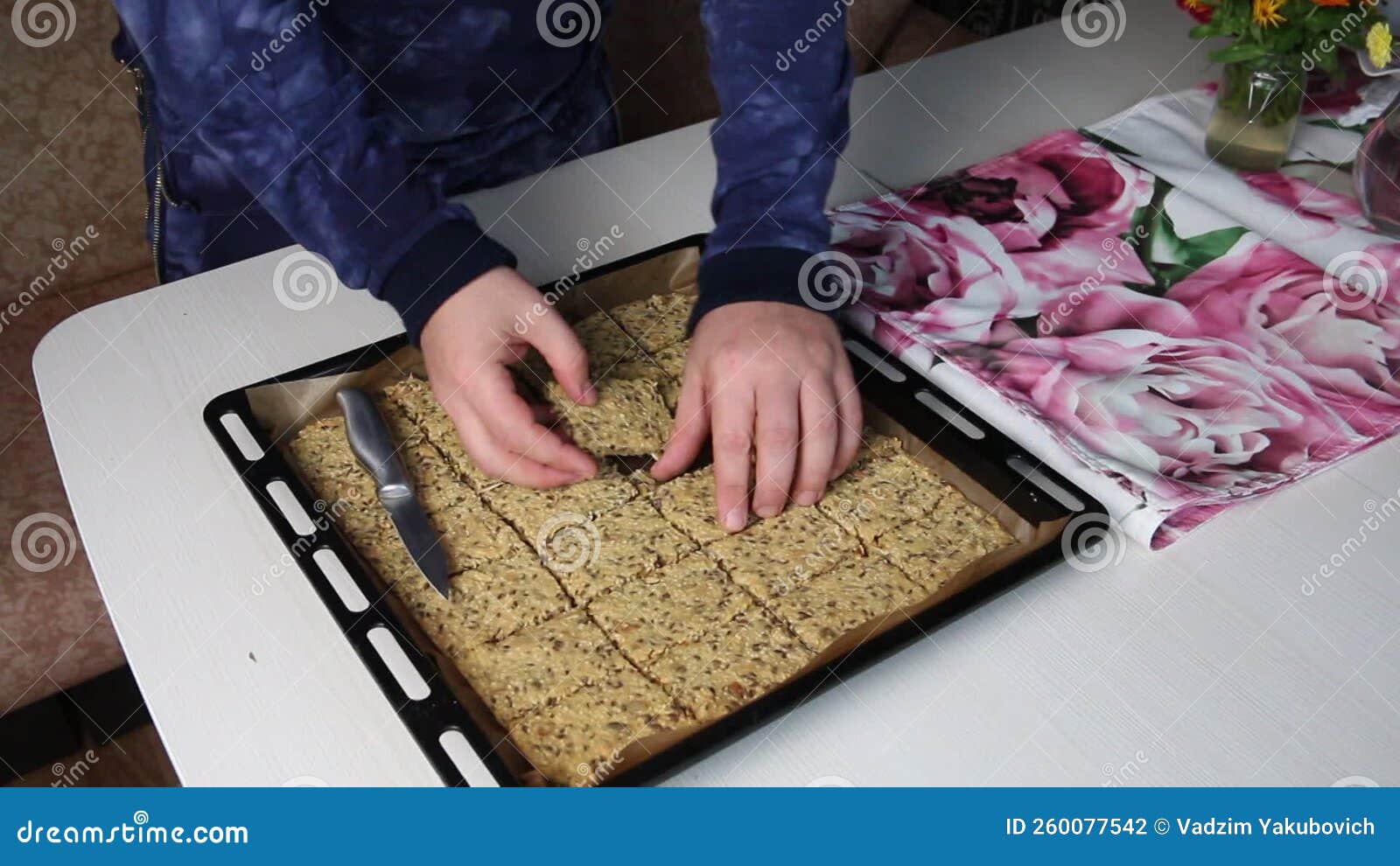 A Man Puts a Baking Sheet with Baked Multi-cereal Loaves on the Table ...