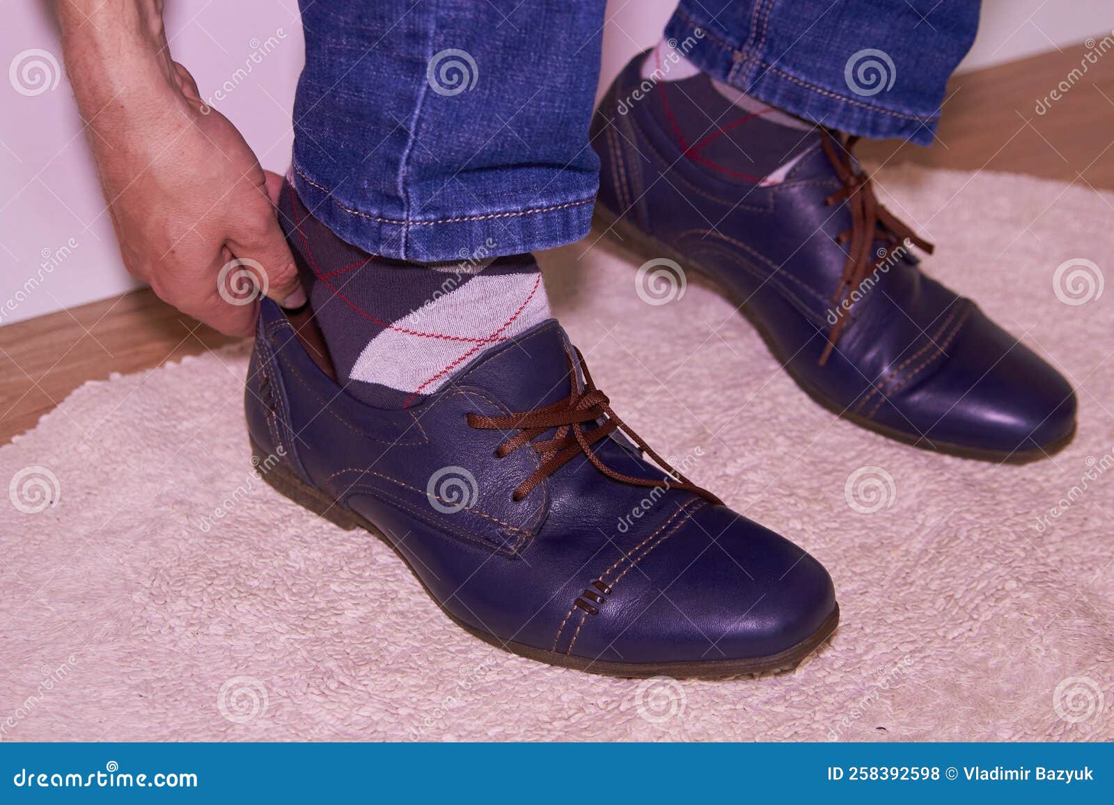 Man Puts on Blue Shoes,a Guy in Jeans Puts on Shoes by the Bed Stock ...