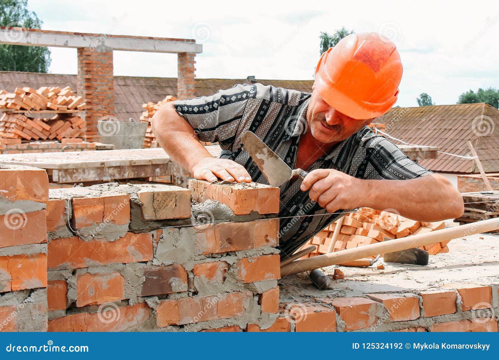 Man puts a brick editorial photography. Image of building - 125324192
