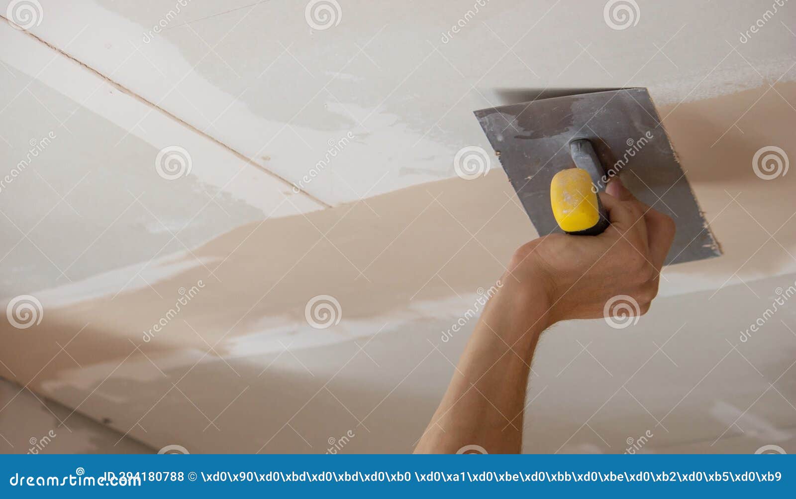 A Man Puts Putty on a Plasterboard Ceiling. Putty for the Joints of ...