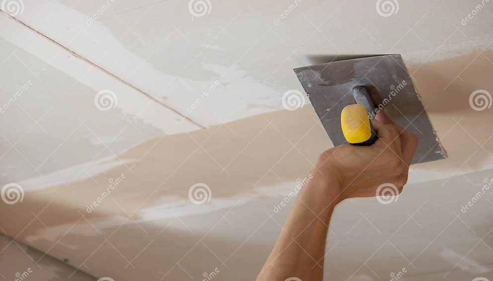 A Man Puts Putty on a Plasterboard Ceiling. Putty for the Joints of ...