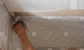 A Man Puts Putty on a Plasterboard Ceiling. Putty for the Joints of ...