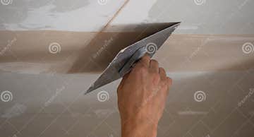A Man Puts Putty on a Plasterboard Ceiling. Putty for the Joints of ...