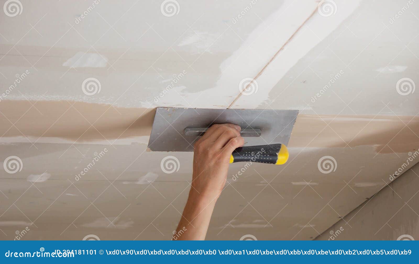 A Man Puts Putty on a Plasterboard Ceiling. Putty for the Joints of ...