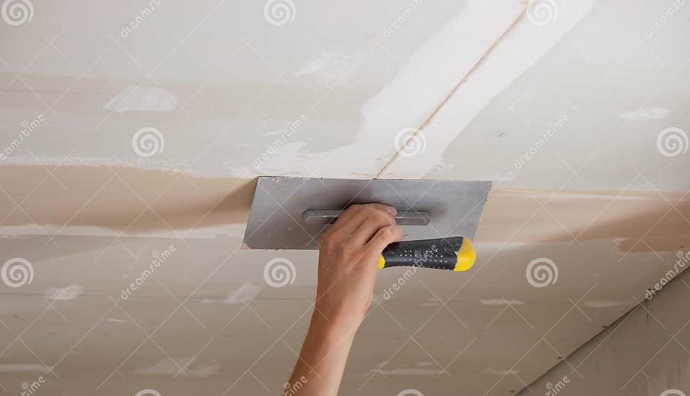 A Man Puts Putty on a Plasterboard Ceiling. Putty for the Joints of ...