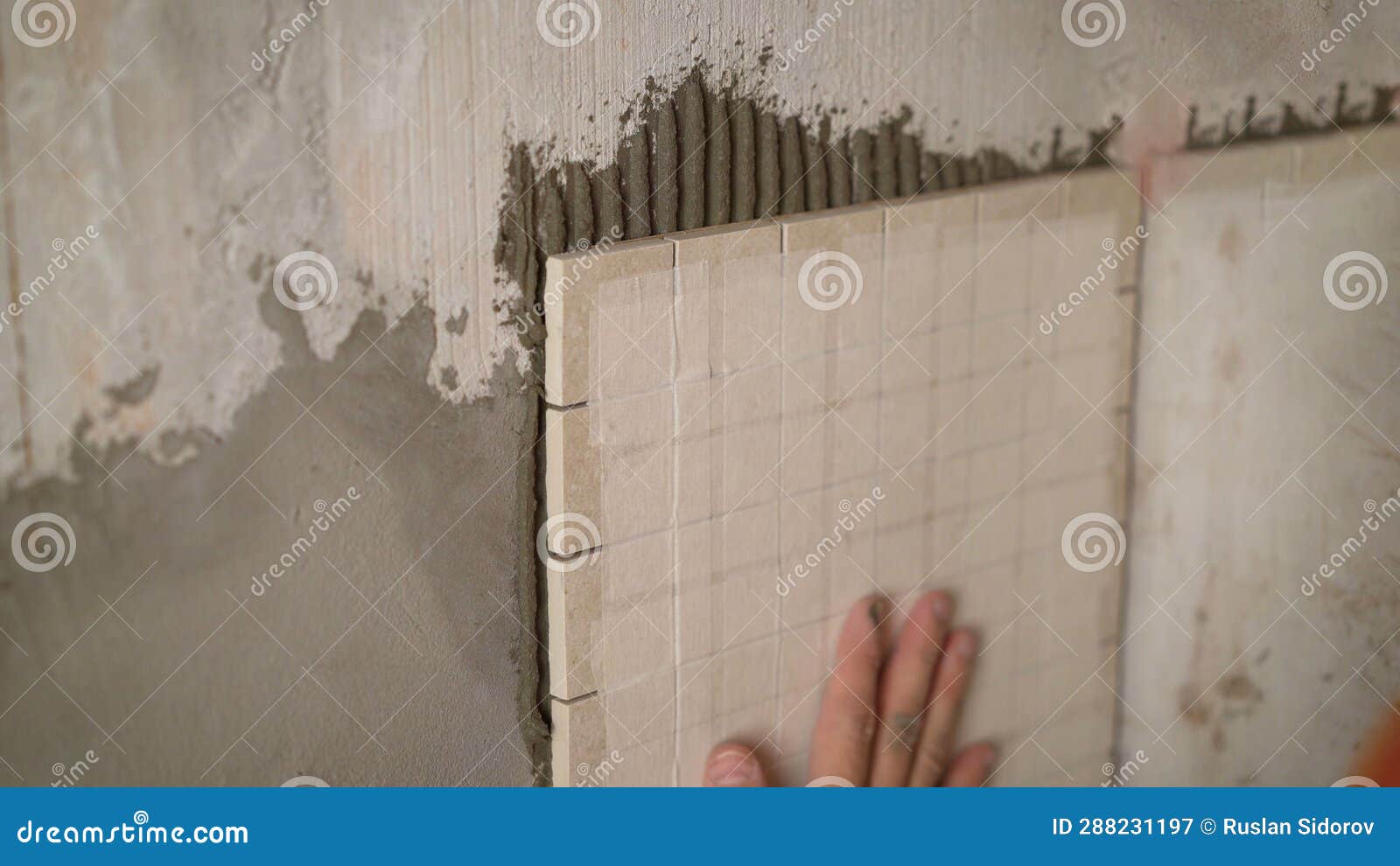 A Man Puts Tiles on the Wall. Construction Work Laying Tiles on the ...