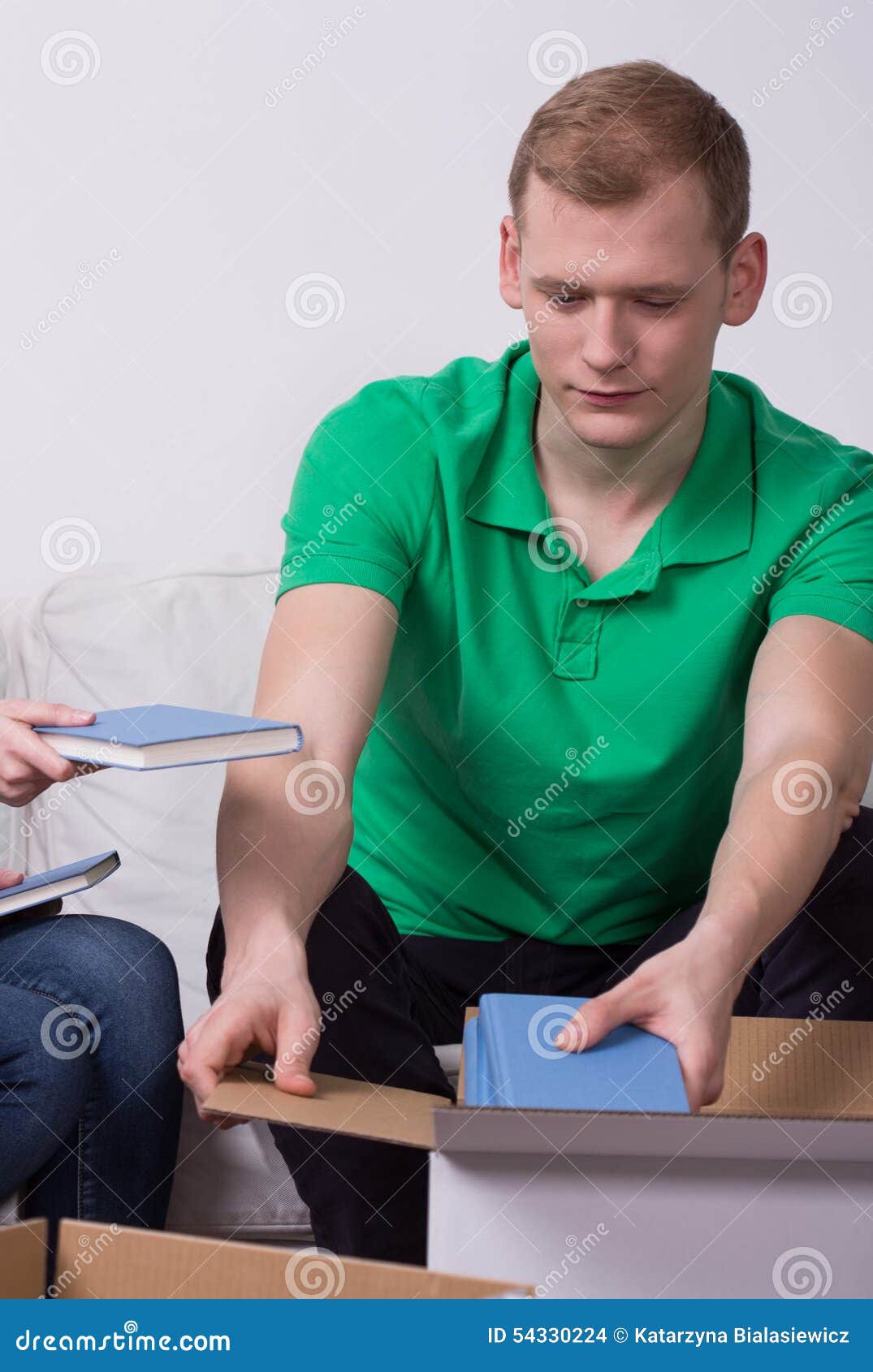 Man putting books into box stock photo. Image of independence - 54330224