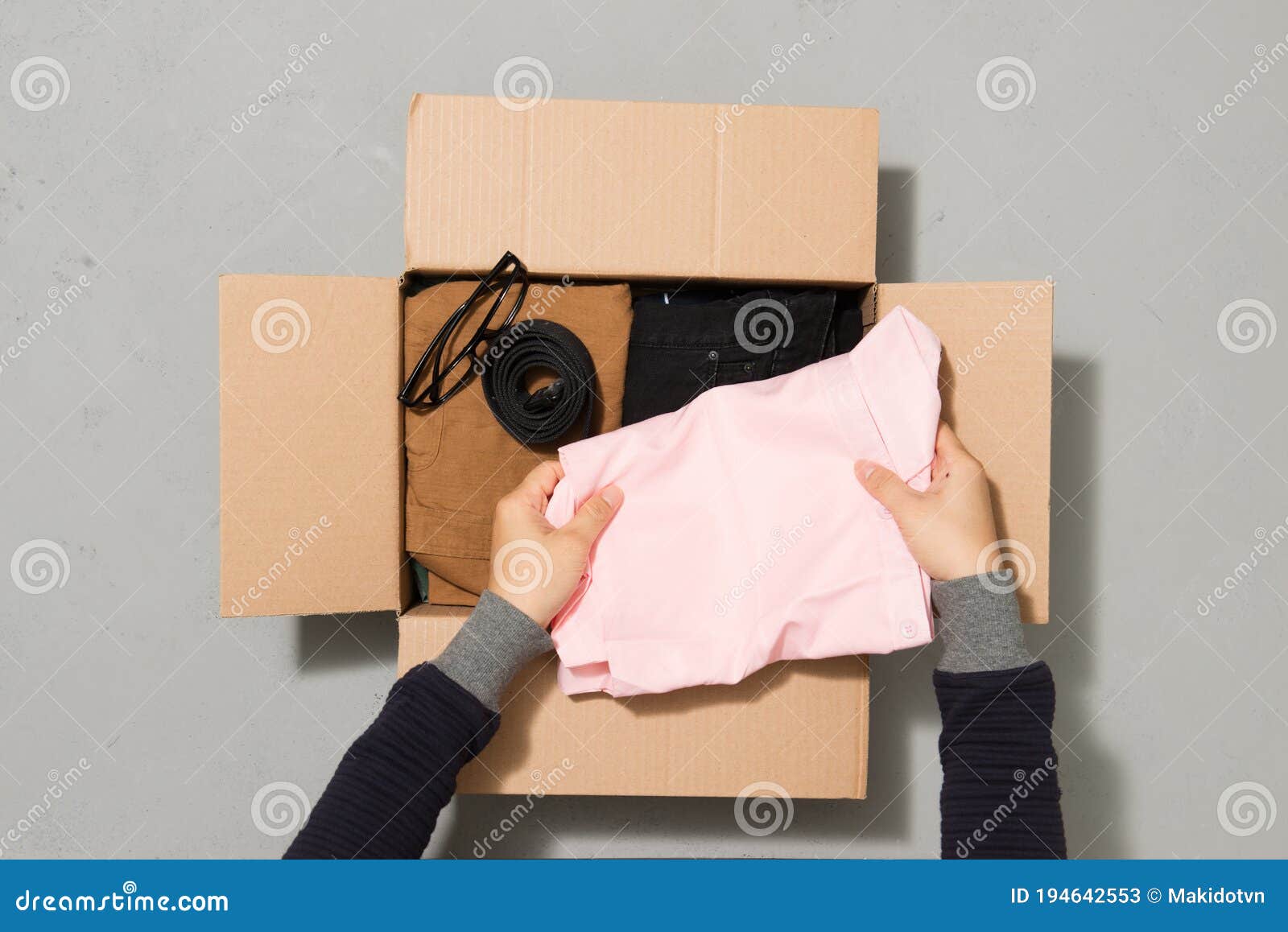 Man Putting Different Clothes in a Carboad Box. Clothes Donation or ...