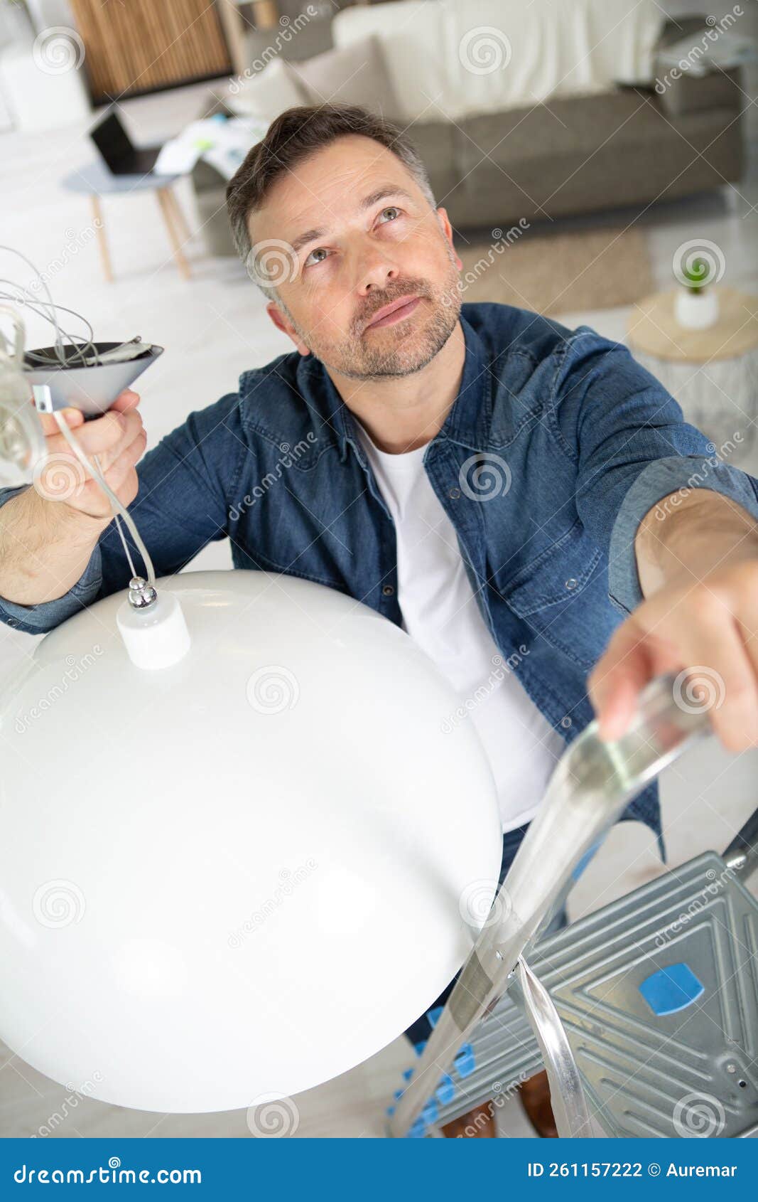 Man putting lamp at home stock photo. Image of efficient - 261157222