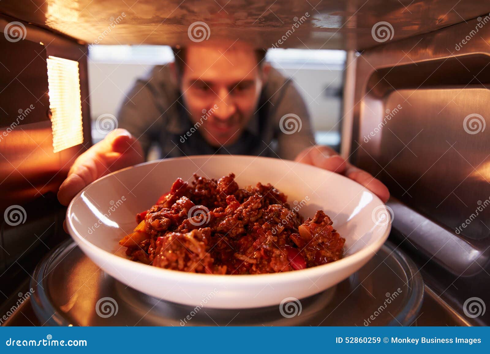 Man Putting Leftover Chili into Microwave Oven To Cook Stock Image ...