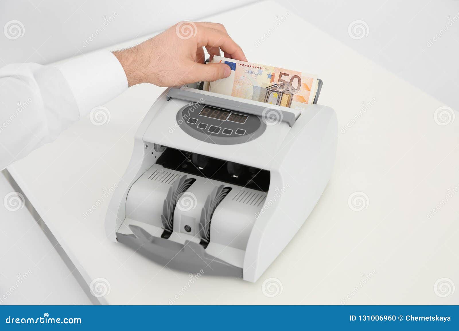 Man Putting Money into Counting Machine on Table, Stock Photo - Image ...