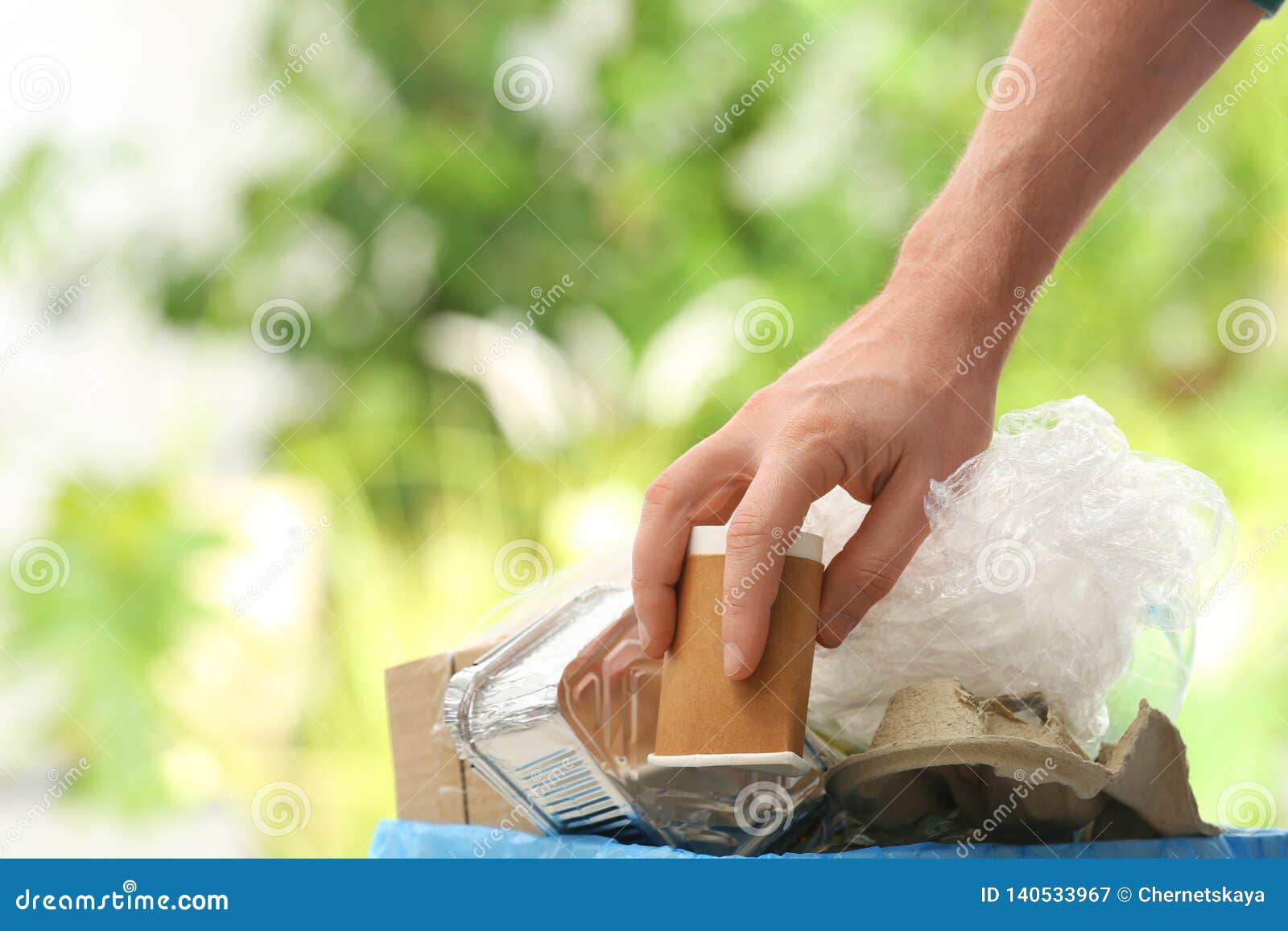 Man Putting Used Paper Cup into Trash Bin on Blurred Background ...