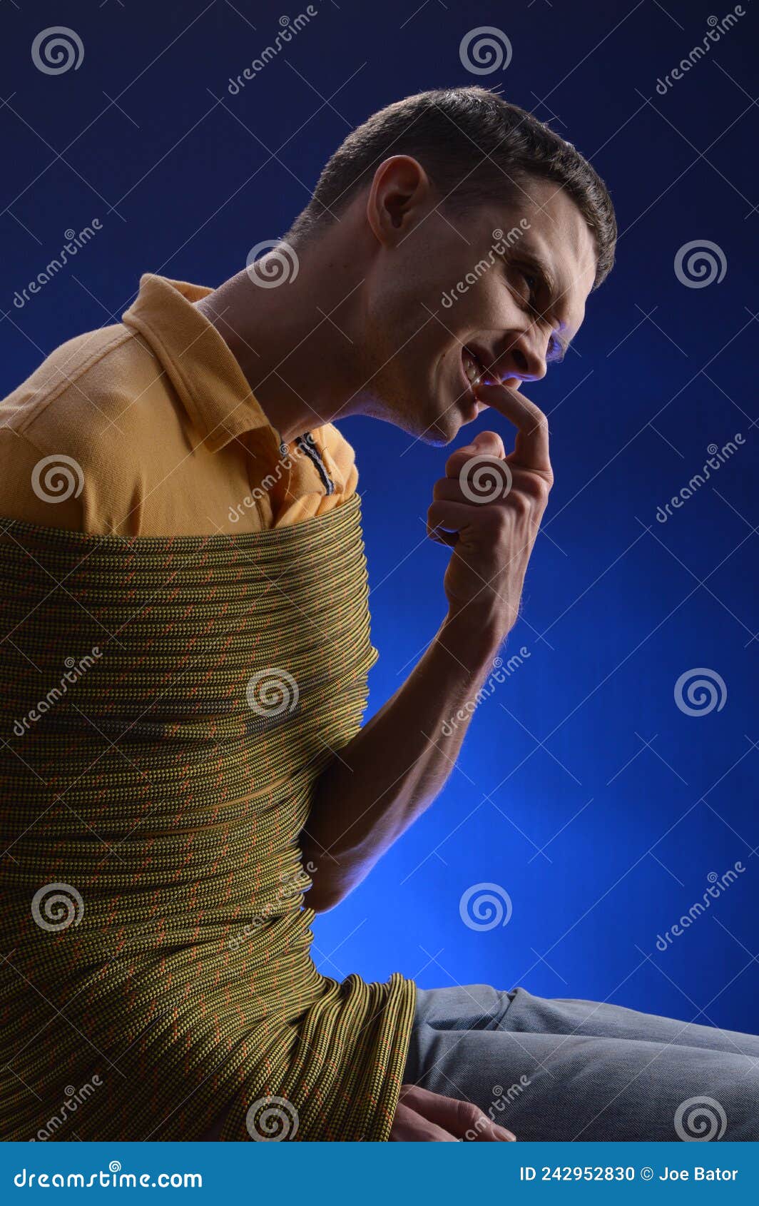 Man Puzzling while Tied Up in Coils of Rope Stock Photo - Image of ...