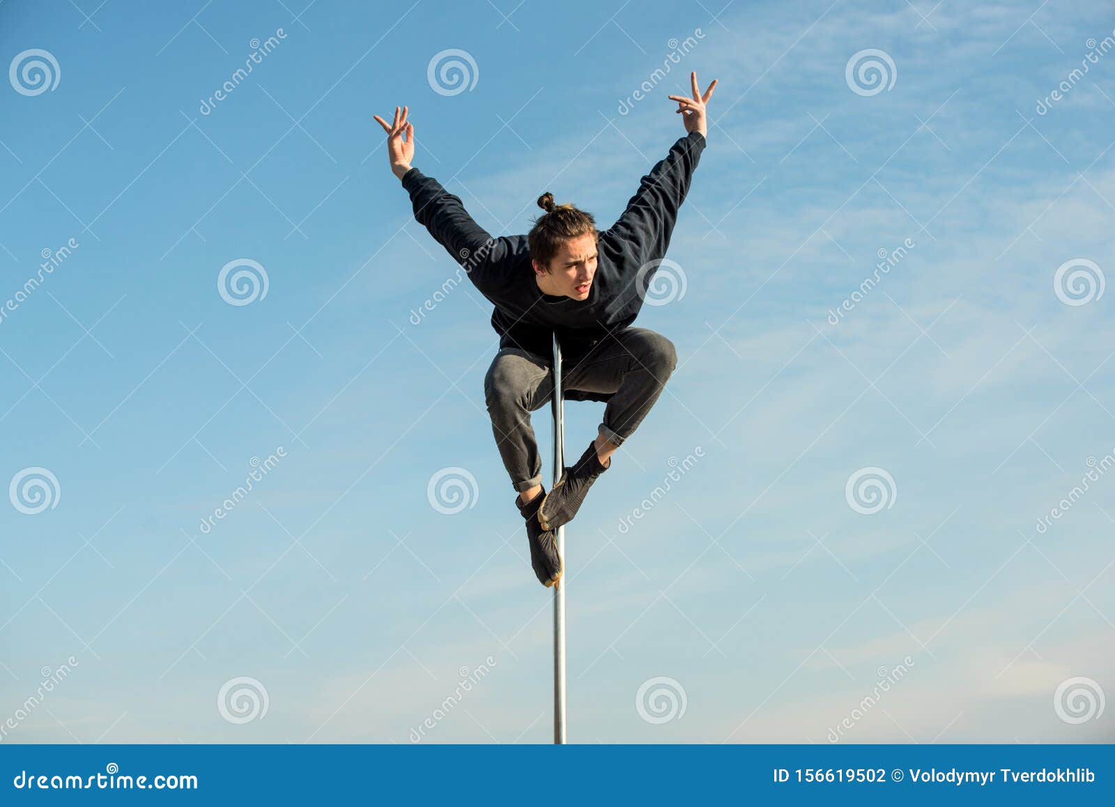 The Man on the Pylon Does the Exercise Against the Backdrop of Blue Sky ...