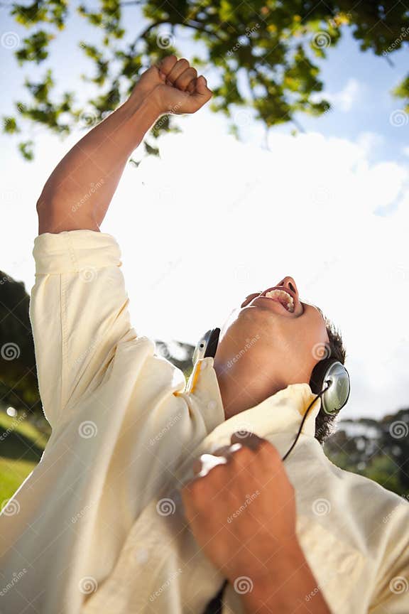 Man Raising His Arm while Using Headphones Stock Image - Image of short ...