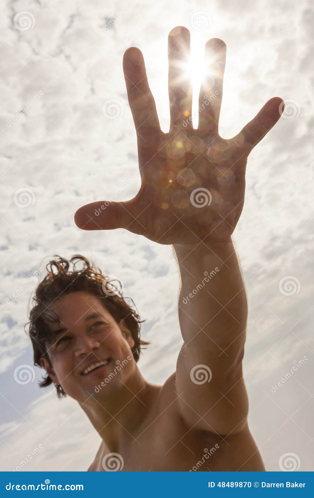 Man Reaching for Sun Flare on Beach Stock Photo - Image of reaching ...
