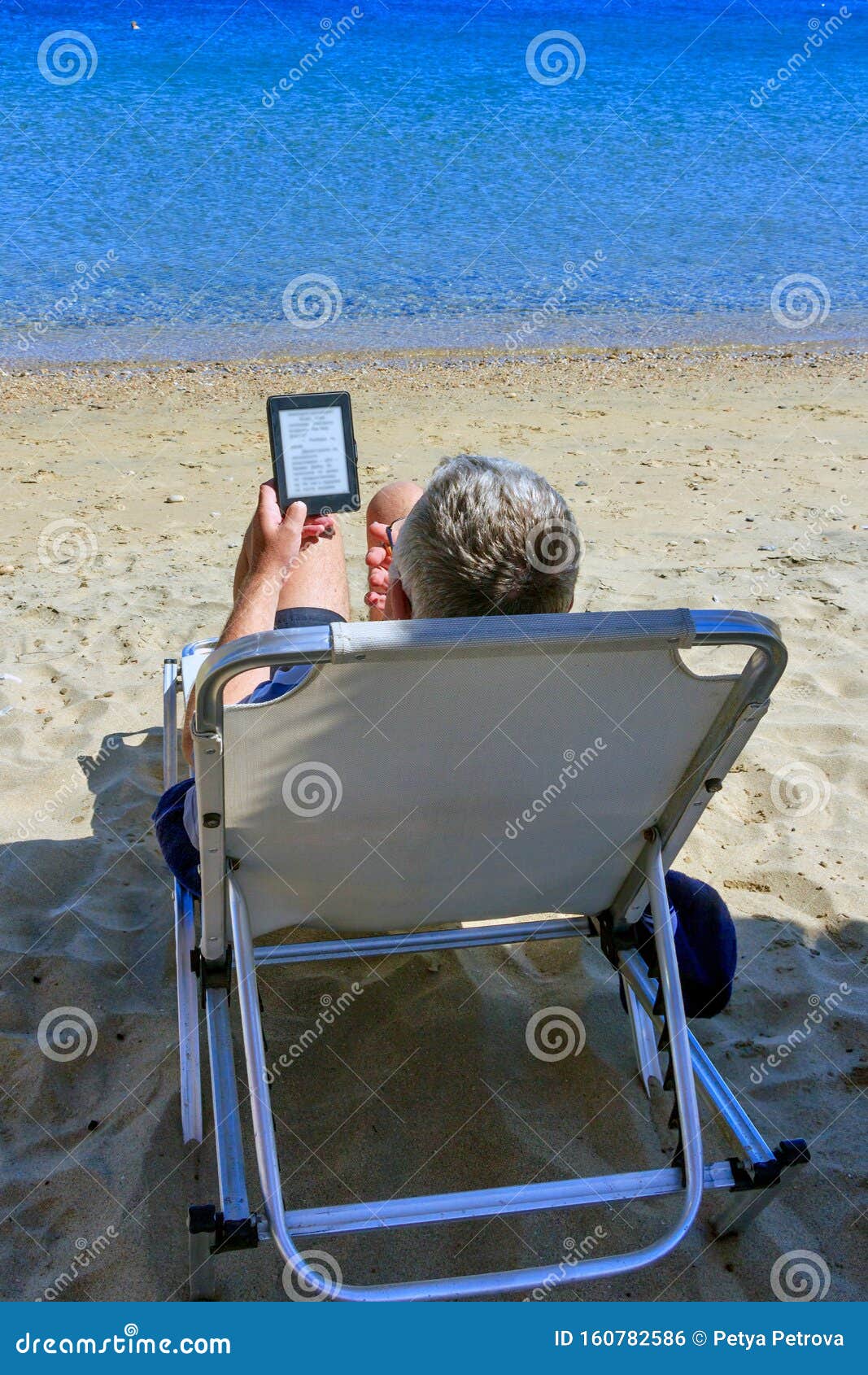 Man reading on the beach stock photo. Image of electronic - 160782586