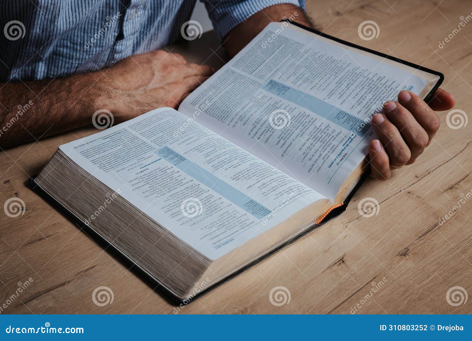 Man is Reading the Bible, Holding with His Hand the Holy Book, in a Low ...