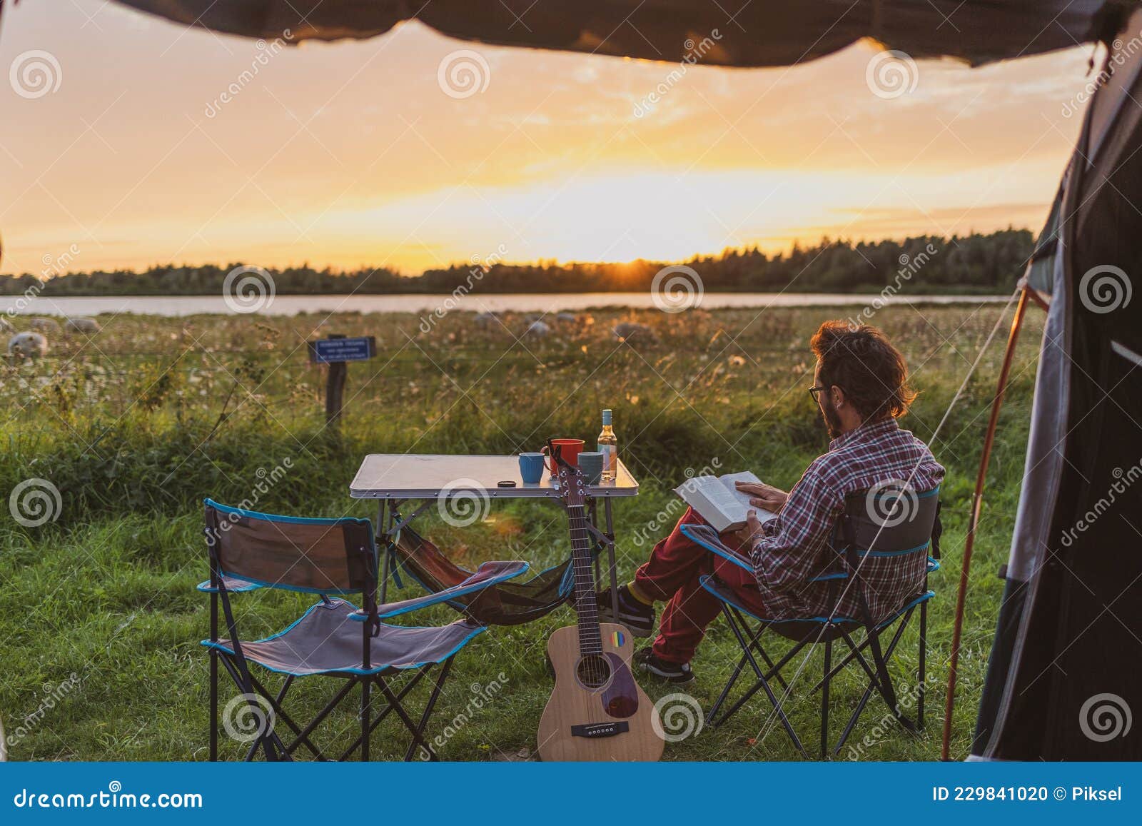 Man Reading a Book at a Campsite Stock Photo - Image of green, park ...