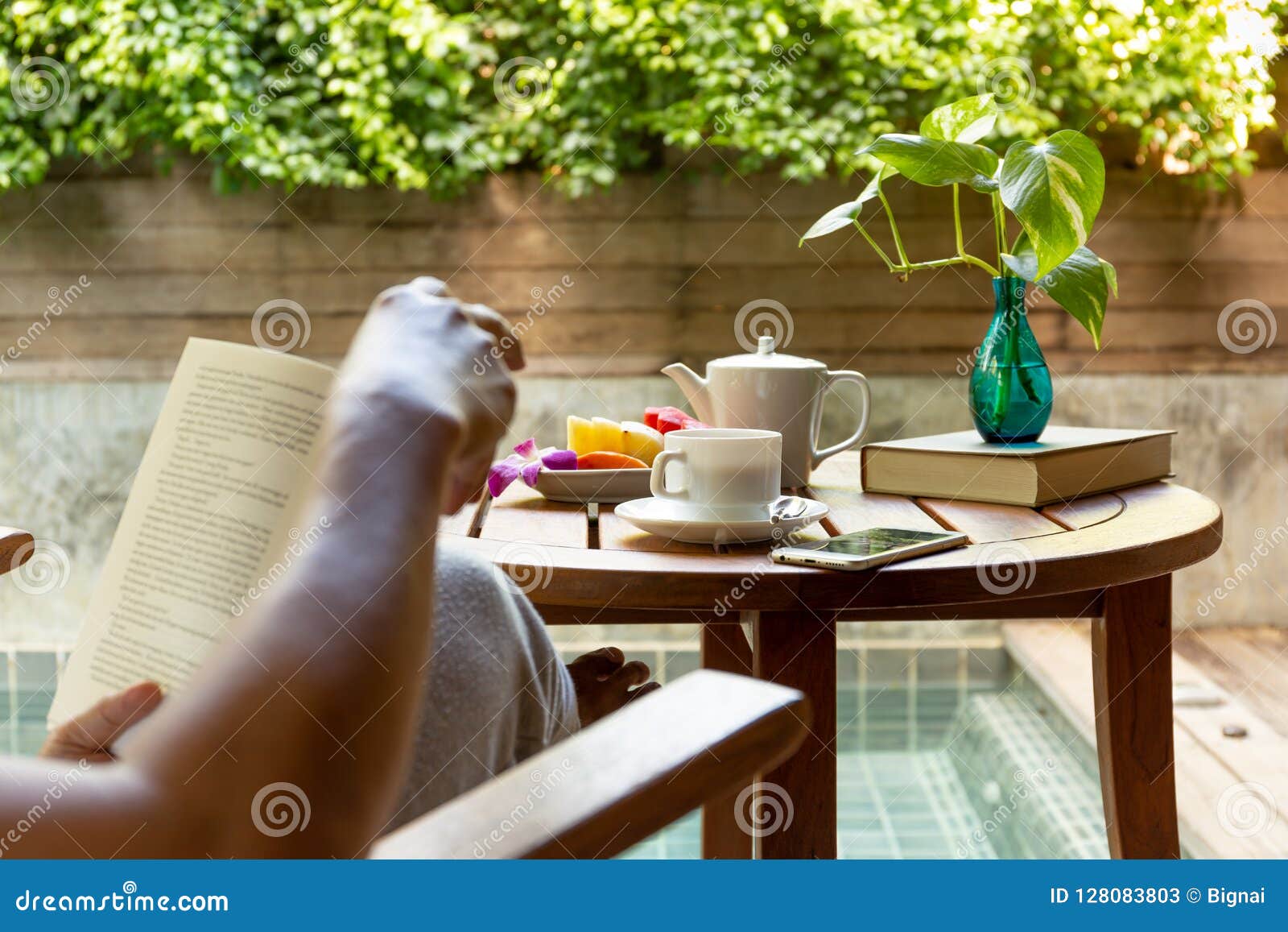 Man Reading a Book with Cup of Coffee and Fresh Fruit on Wooden Table ...