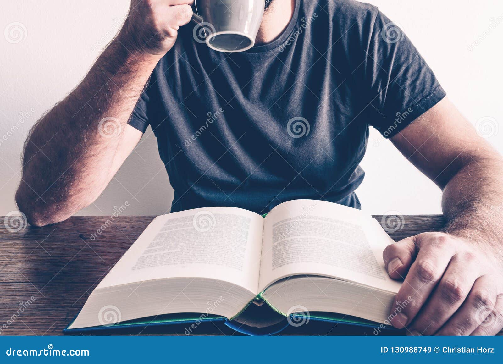 Man Reading Book at Kitchen Table while Drinking Coffee Stock Image ...