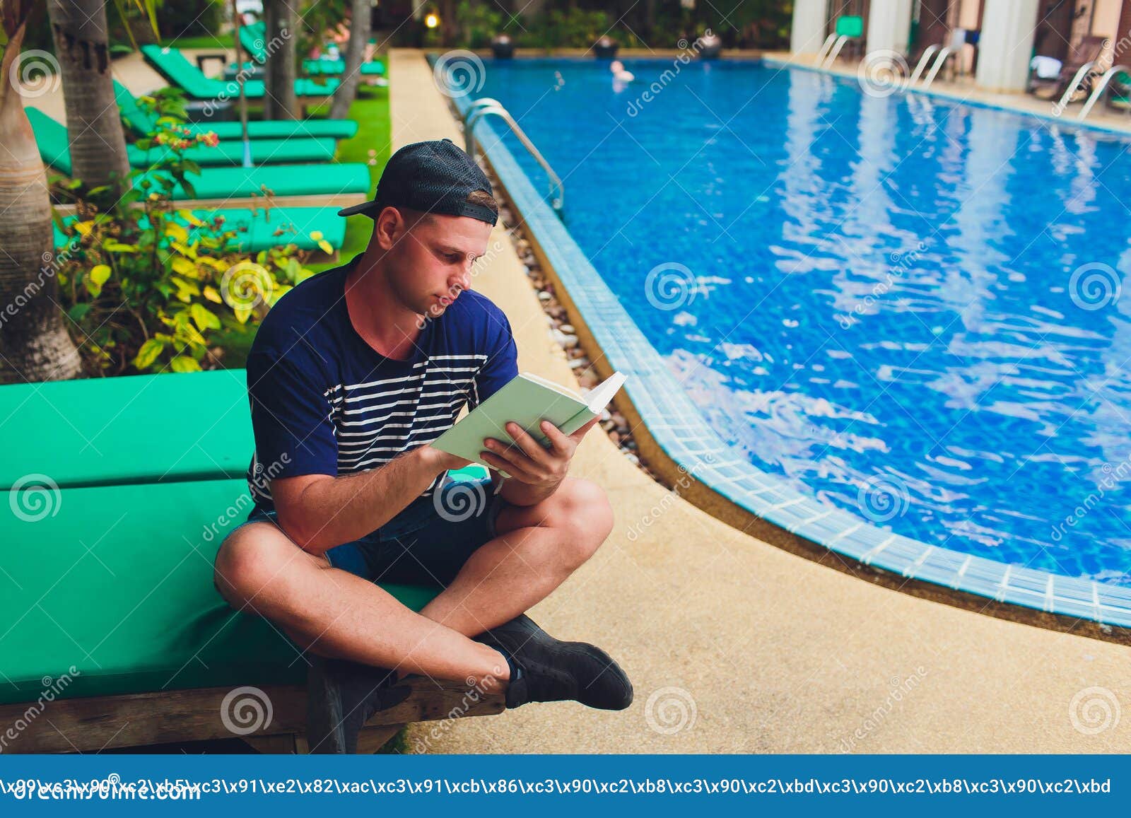 A Man Reading Book beside Swimming Pool in the Garden. Stock Image ...