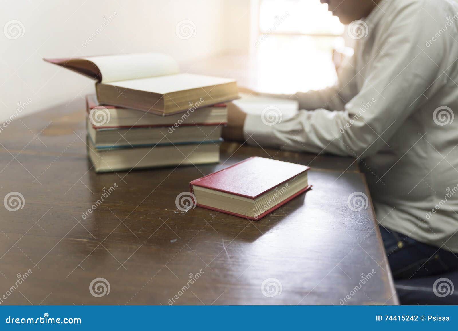 Man Reading Book with Textbook Stack on Wooden Desk Stock Photo - Image ...