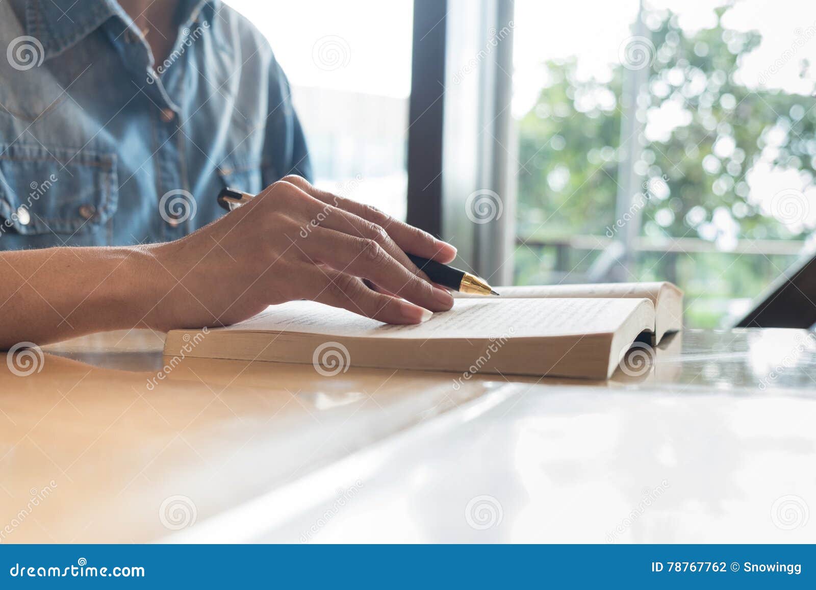 Man Reading a Book and Writing Notes on Wooden Table on Sunset. Stock ...