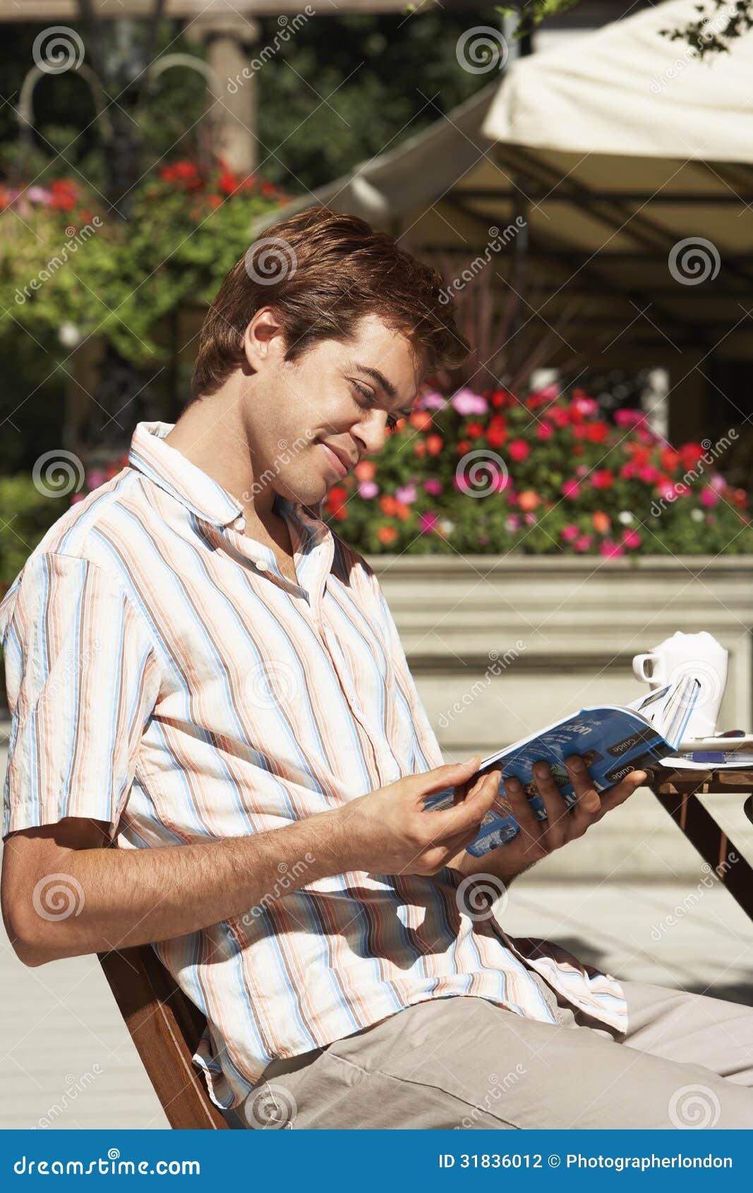 Man Reading Guidebook at Outdoor Cafe Stock Photo - Image of brunette ...